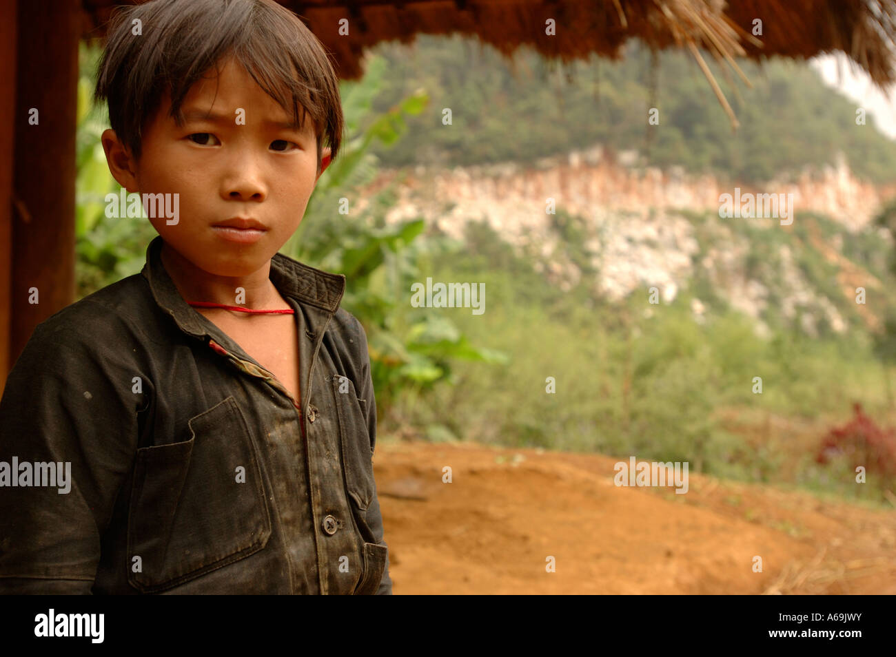 A Blue Hmong indigenous boy wearing traditional cloth proudly stands in ...