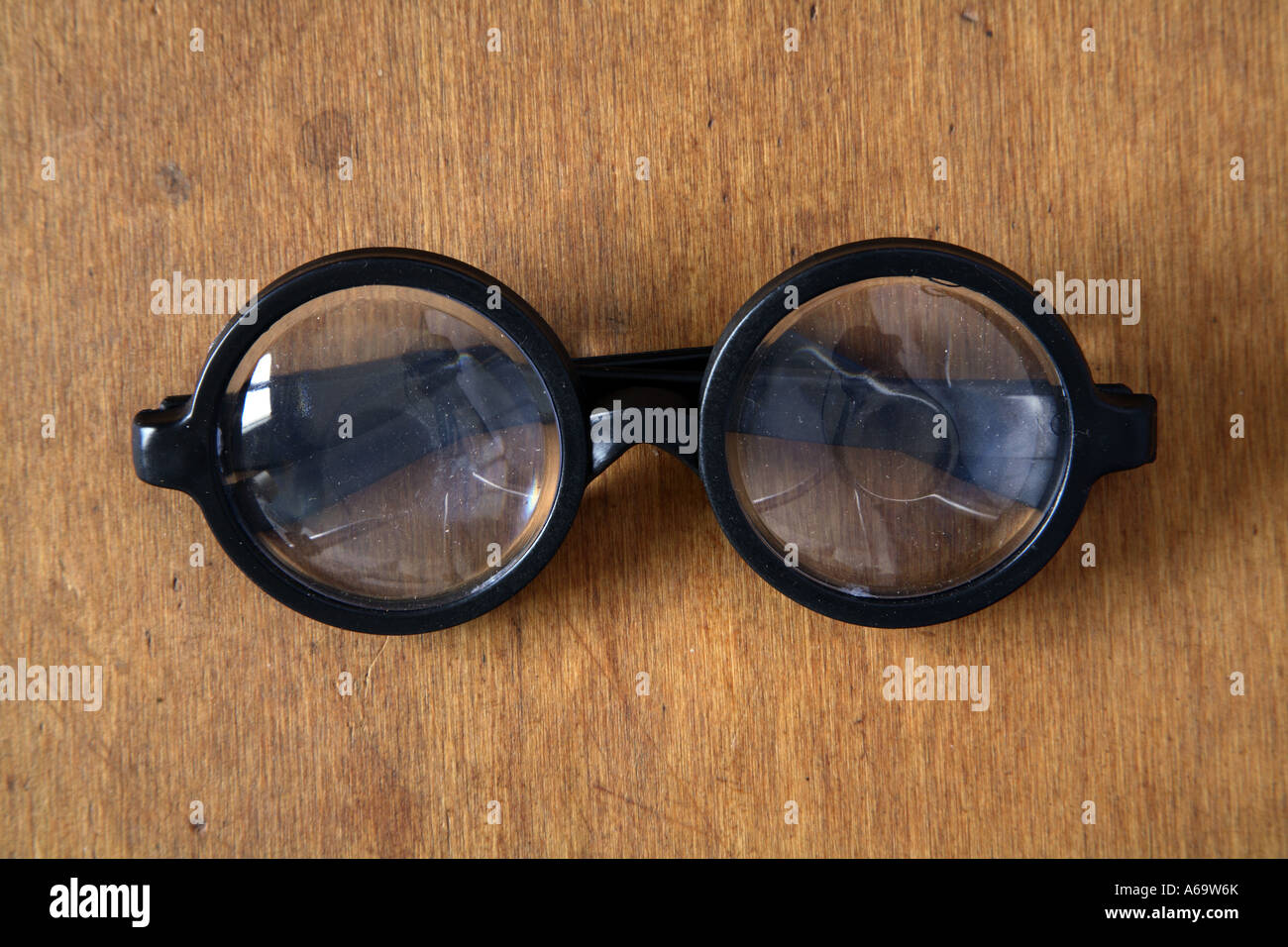 plastic reading glasses on wood Stock Photo - Alamy