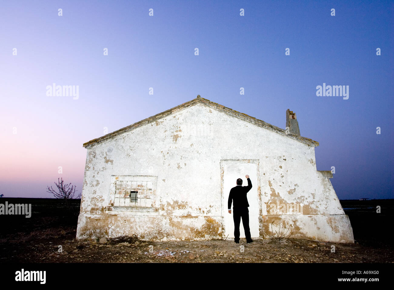 Man knocking on an abandoned house blocked off door at dusk. image ...