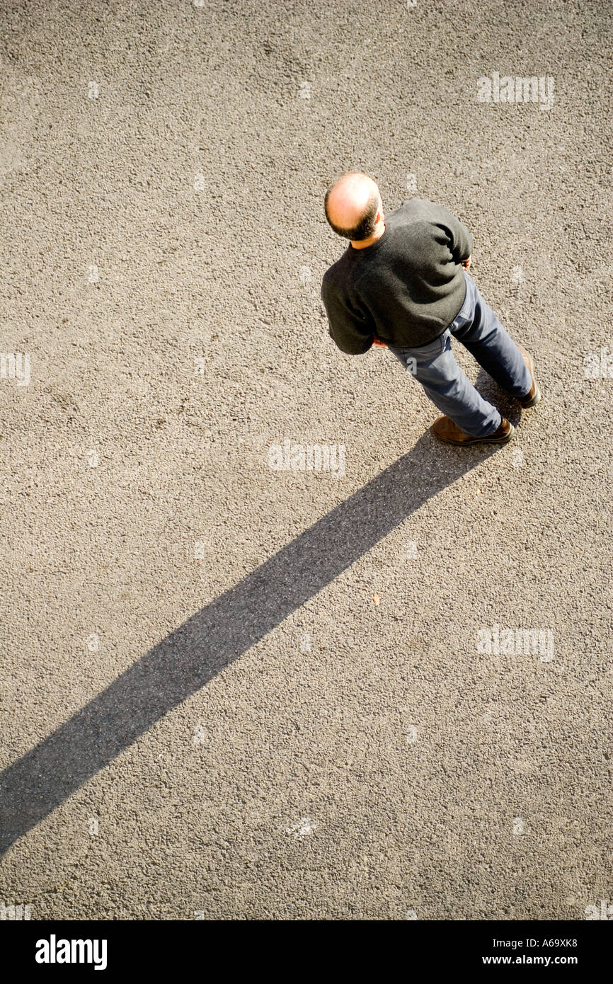 Graphic, high angle view of a bald man and his shadow on pavement Stock ...