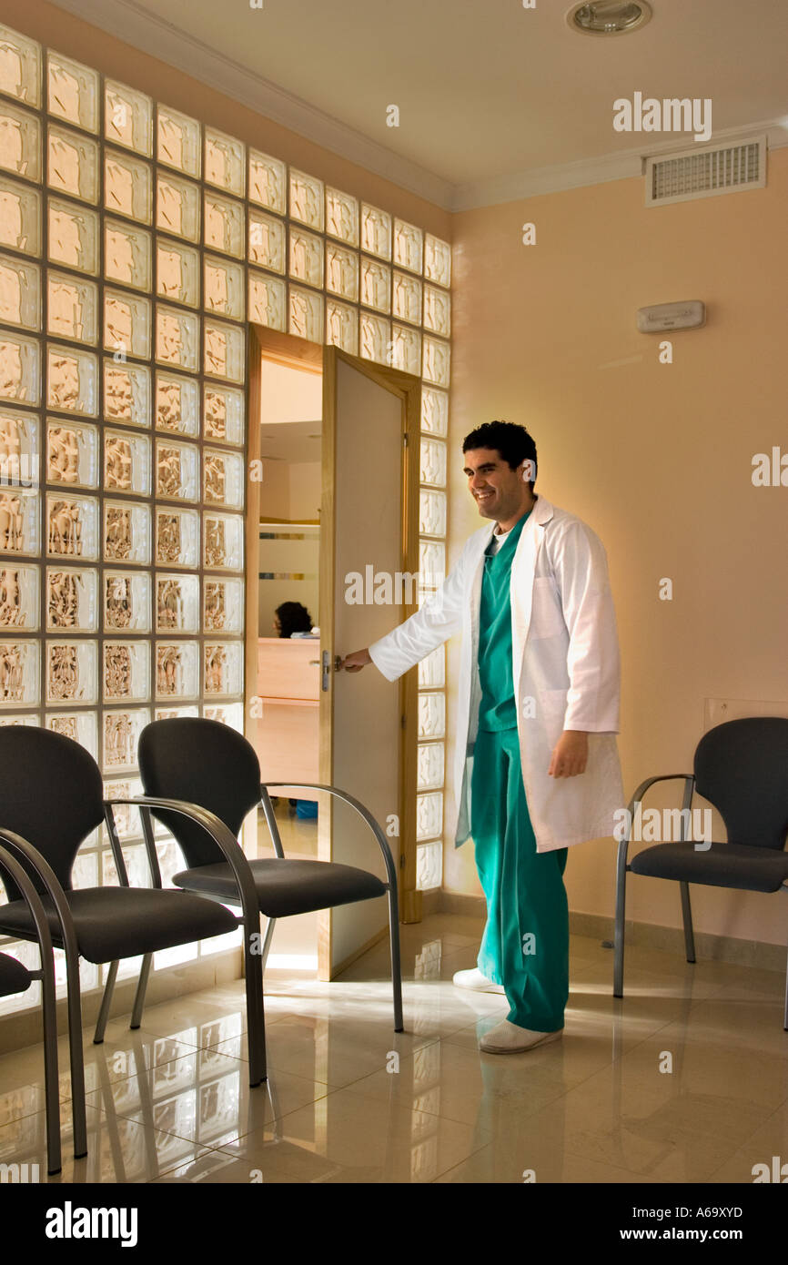 Doctor opening a door in a clinic Stock Photo - Alamy