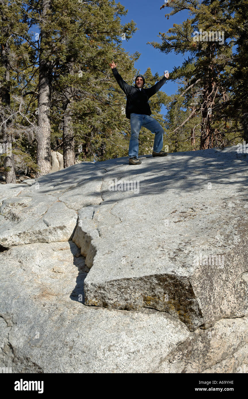 Young man on top of boulder with arms up in the air Stock Photo - Alamy
