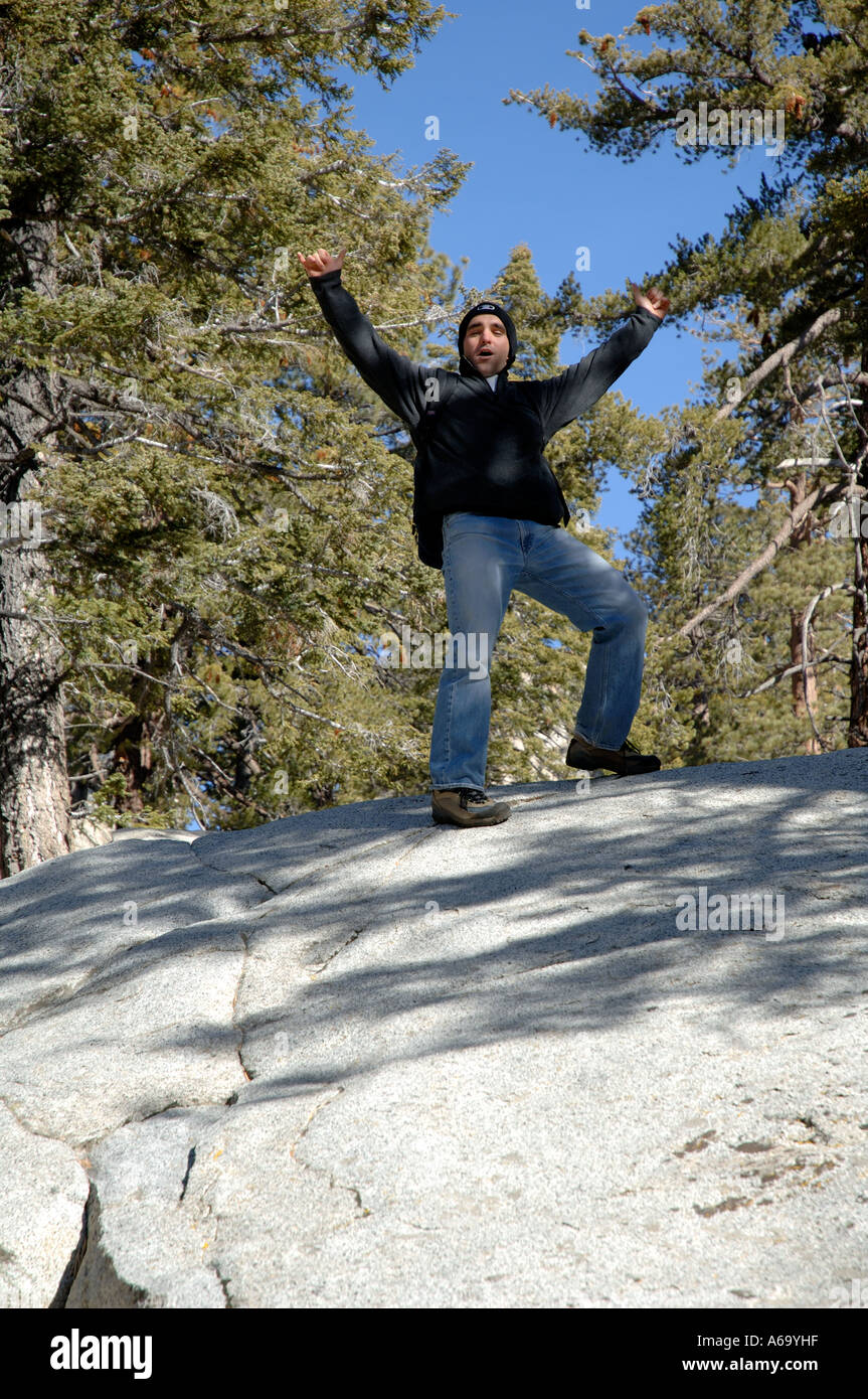 Young man on top of boulder with arms up in the air Stock Photo - Alamy