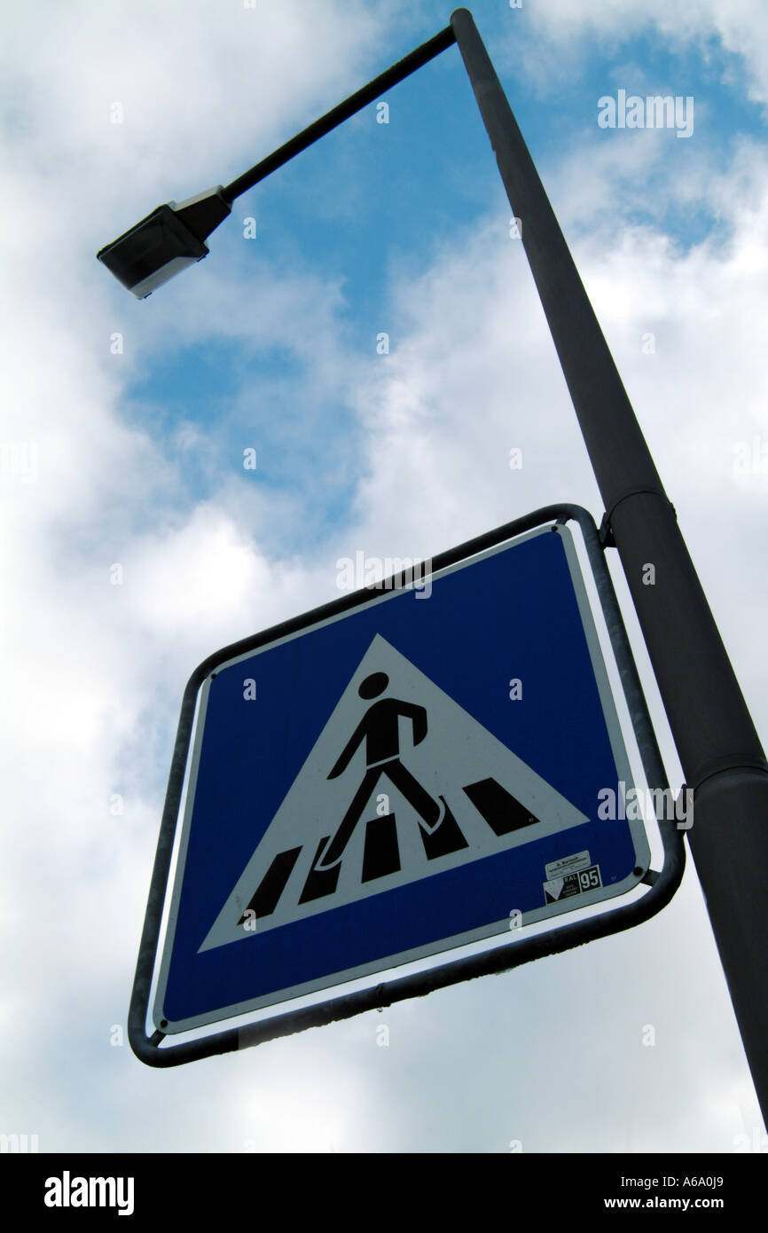 pedestrian walking crossing sign blue white black day daylight ...