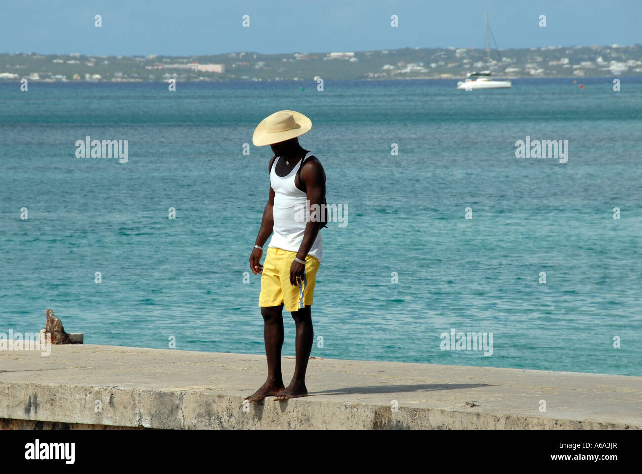 West Indies man on pier, sea in background Stock Photo - Alamy