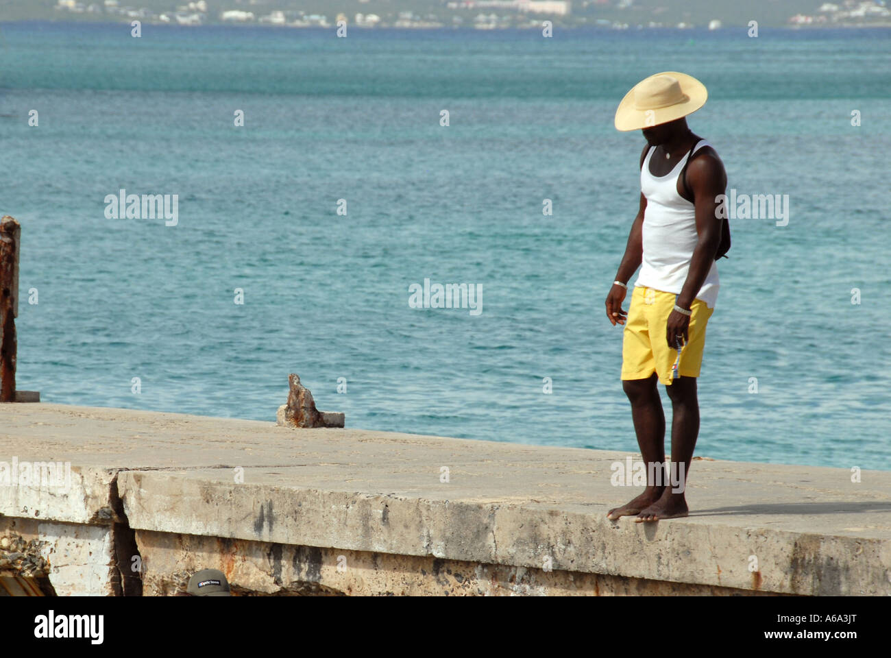 West Indies man on pier, sea in background Stock Photo - Alamy