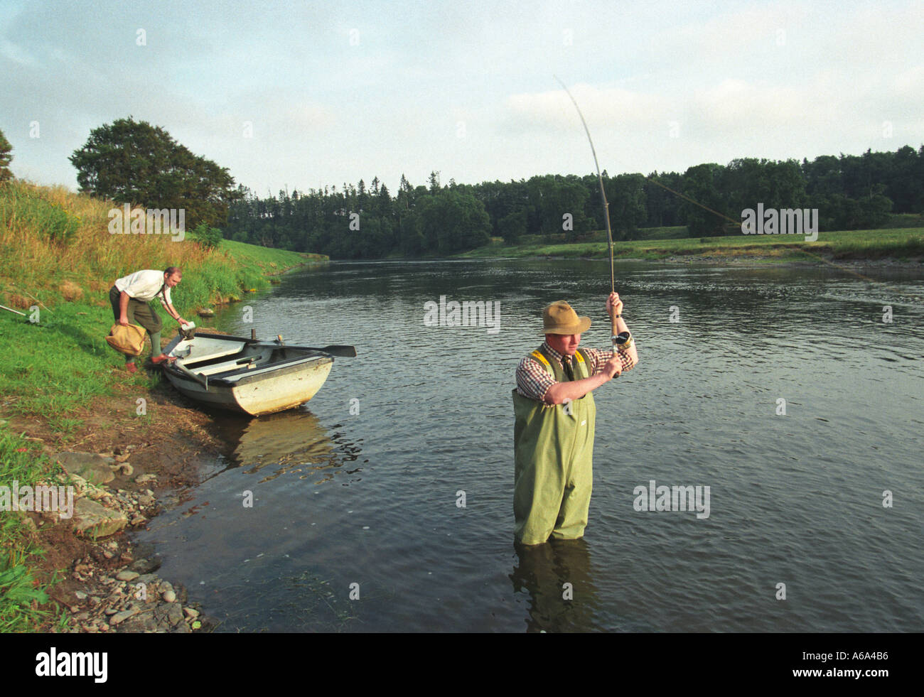 Salmon fishing on river Tweed with Ghillie on riverbank Stock Photo - Alamy