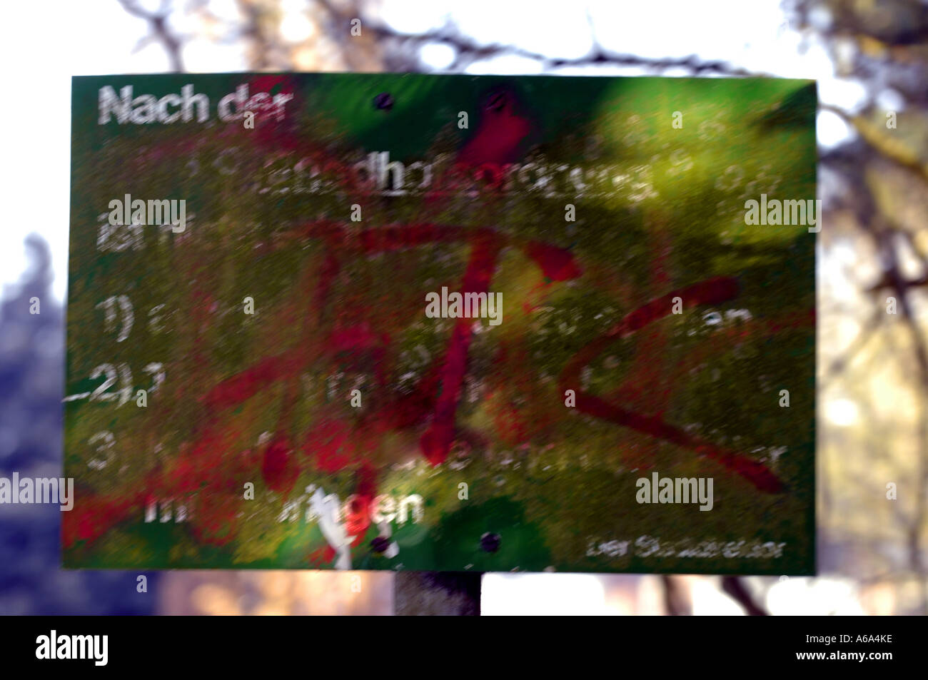 green sign sprayed over in red spraypaint defeced illegible unreadable ...