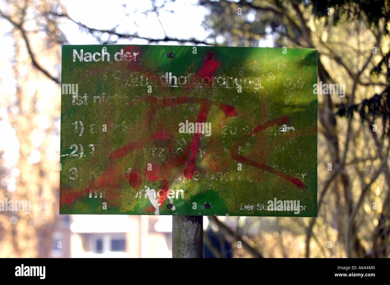 green sign sprayed over in red spraypaint defeced illegible unreadable ...