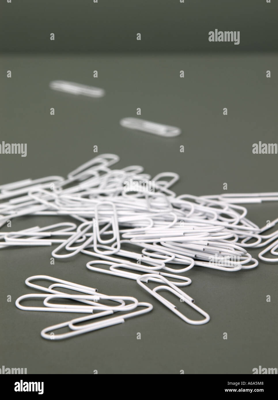 white paper clips scattered on a green background Stock Photo - Alamy