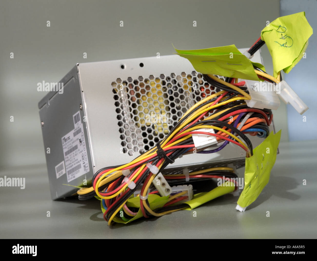 a computer power supply removed from case with yellow post it tags ...