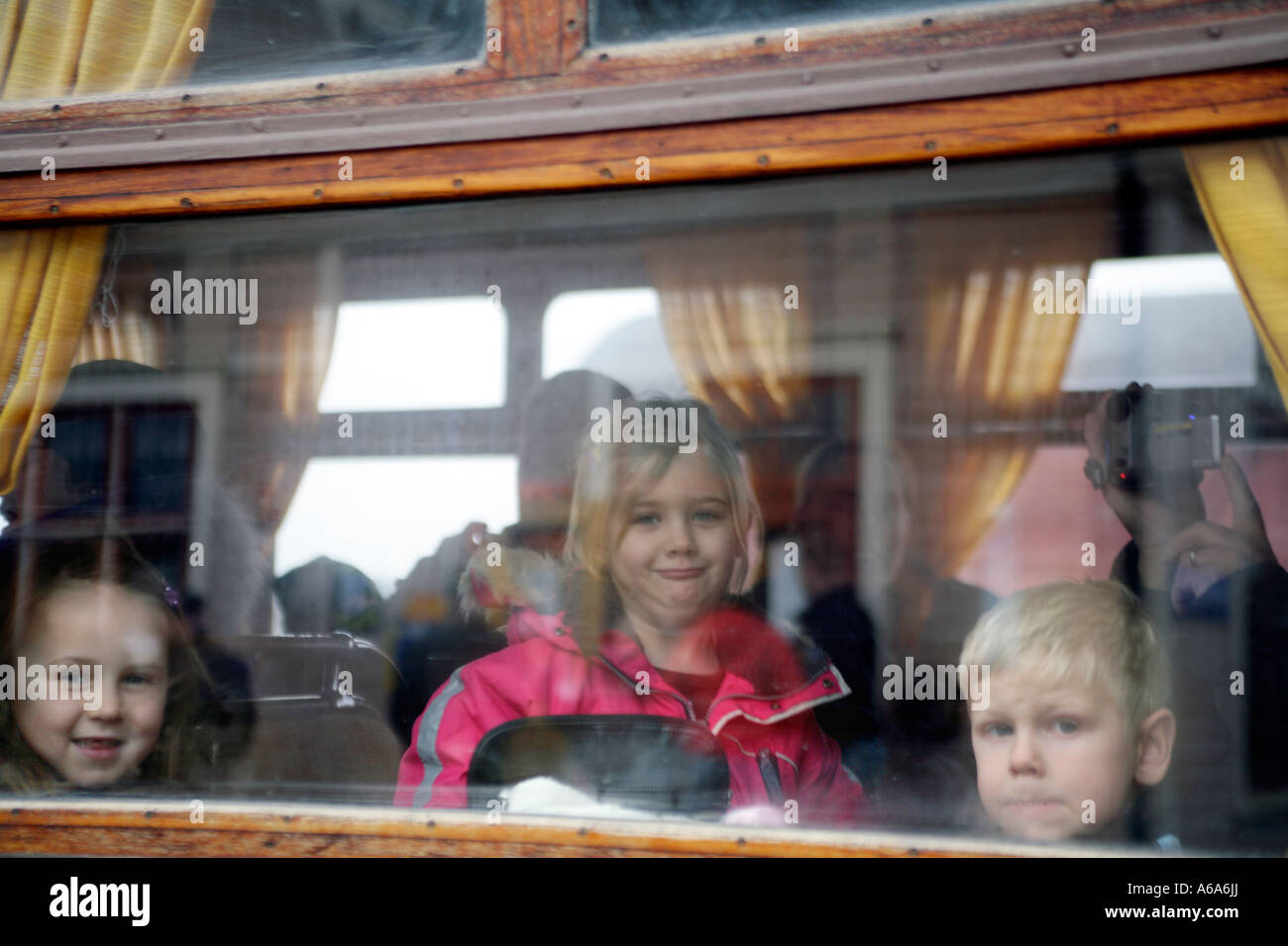 Children behind a window with reflections on glass panes in an old ...
