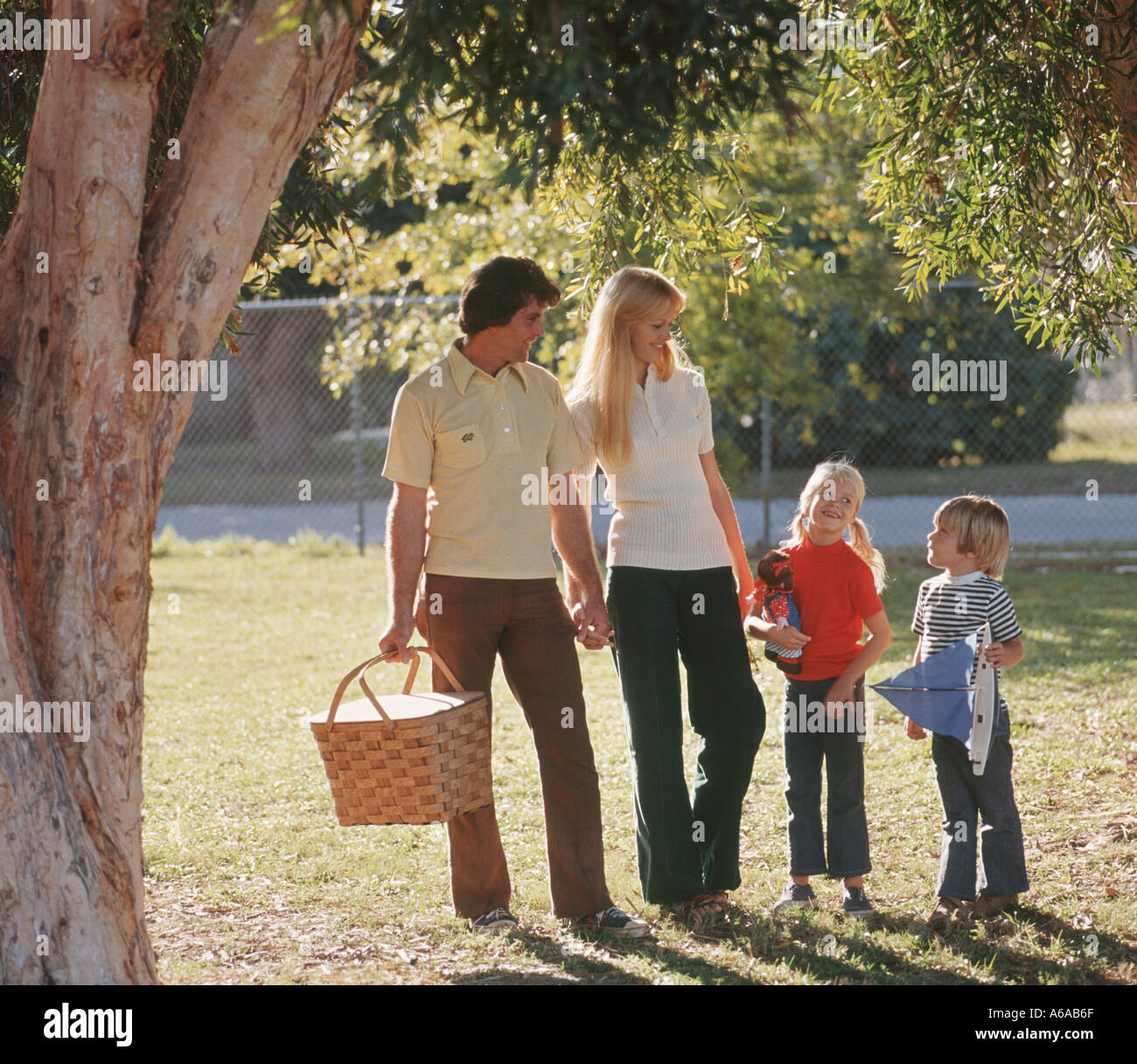 Family of four going on a picnic in a park Stock Photo - Alamy