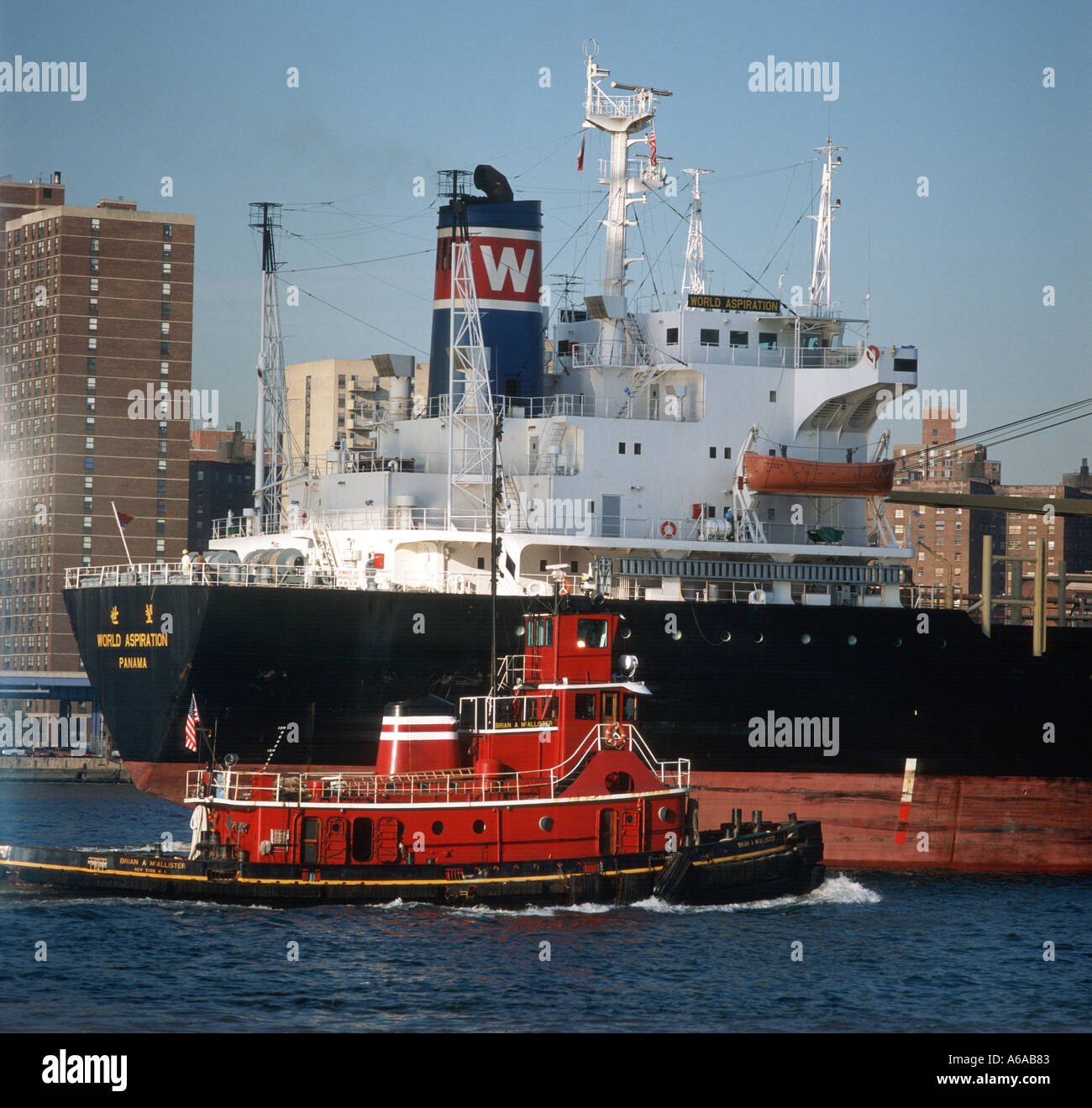 tugboat working alongside a large freighter in New York harbor Stock ...