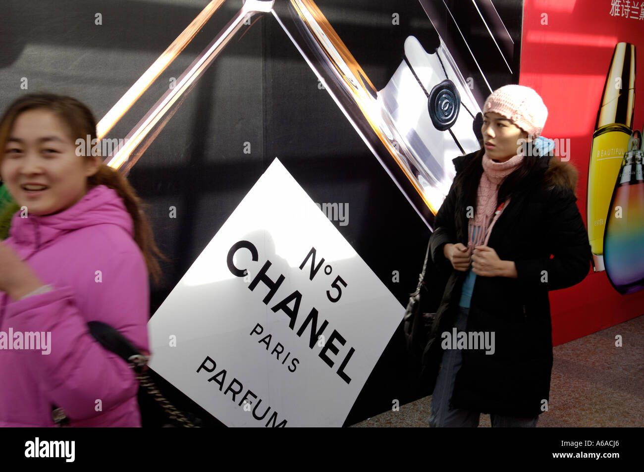 Two ladies walk past a billboard featuring Paris Chanel No 5 in Beijing ...