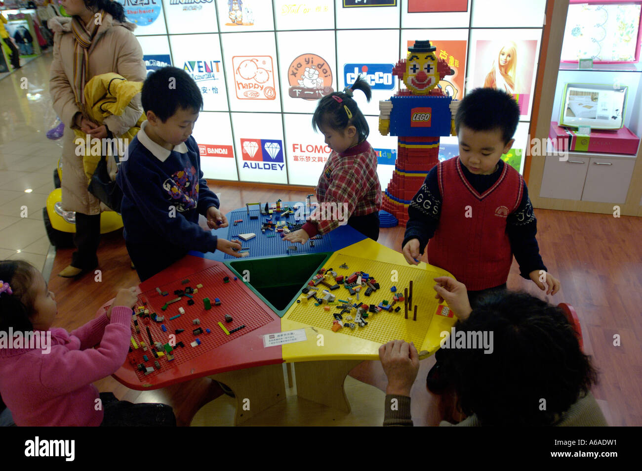 Chinese children play lego in front of a wall featuring world toys ...