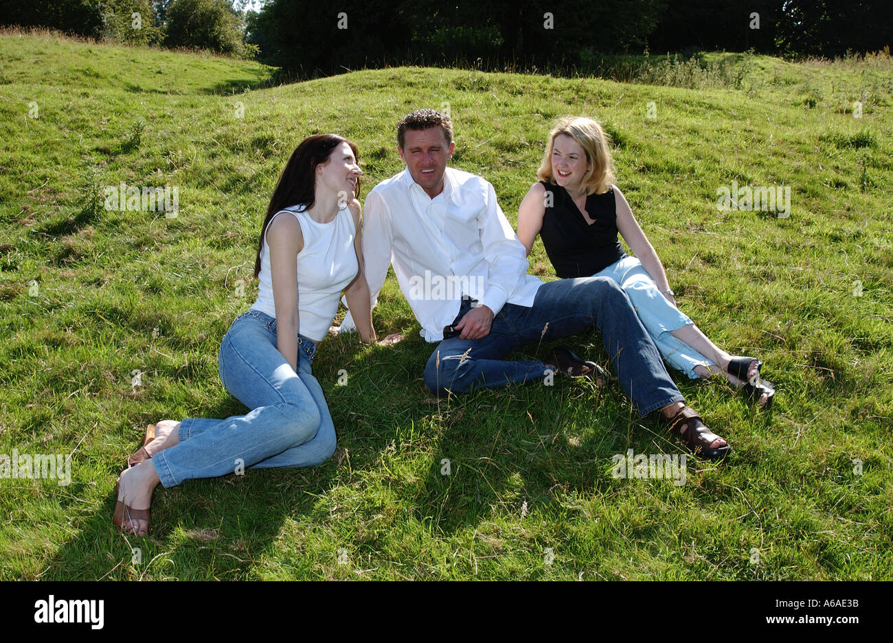 3 friends sitting outside talking during summer Stock Photo - Alamy