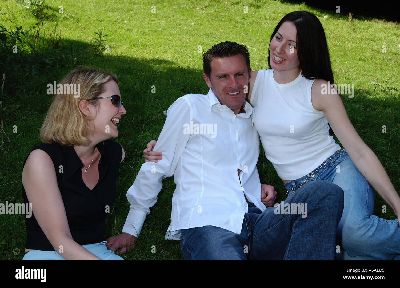 3 friends sitting outside talking during summer Stock Photo - Alamy
