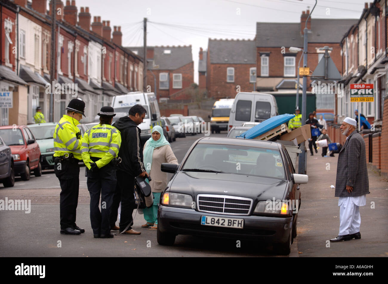 A POLICEMAN AND POLICEWOMAN TALK TO LOCAL RESIDENTS IN BIRMINGHAM AFTER ...