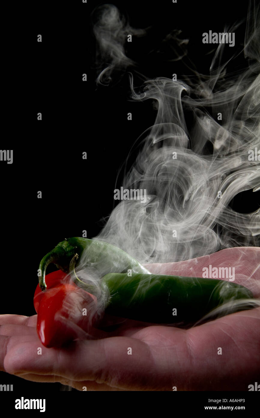 Smoking red and green peppers in palm of hand Stock Photo - Alamy