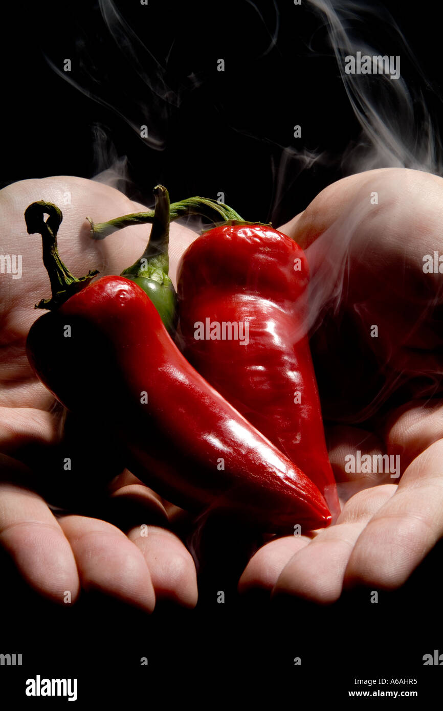 Smoking red and green peppers in palm of hand Stock Photo - Alamy