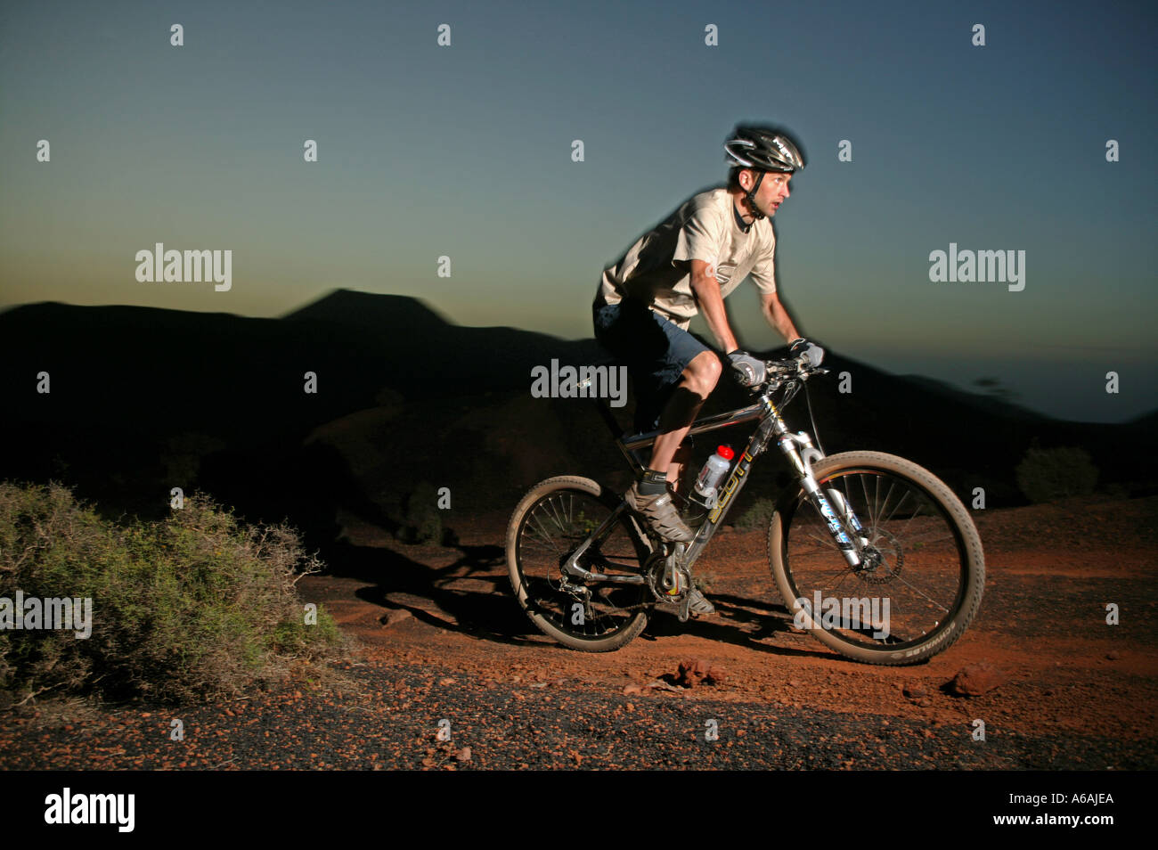 Mountain Biker riding in a rocky landscape at Dusk Stock Photo - Alamy