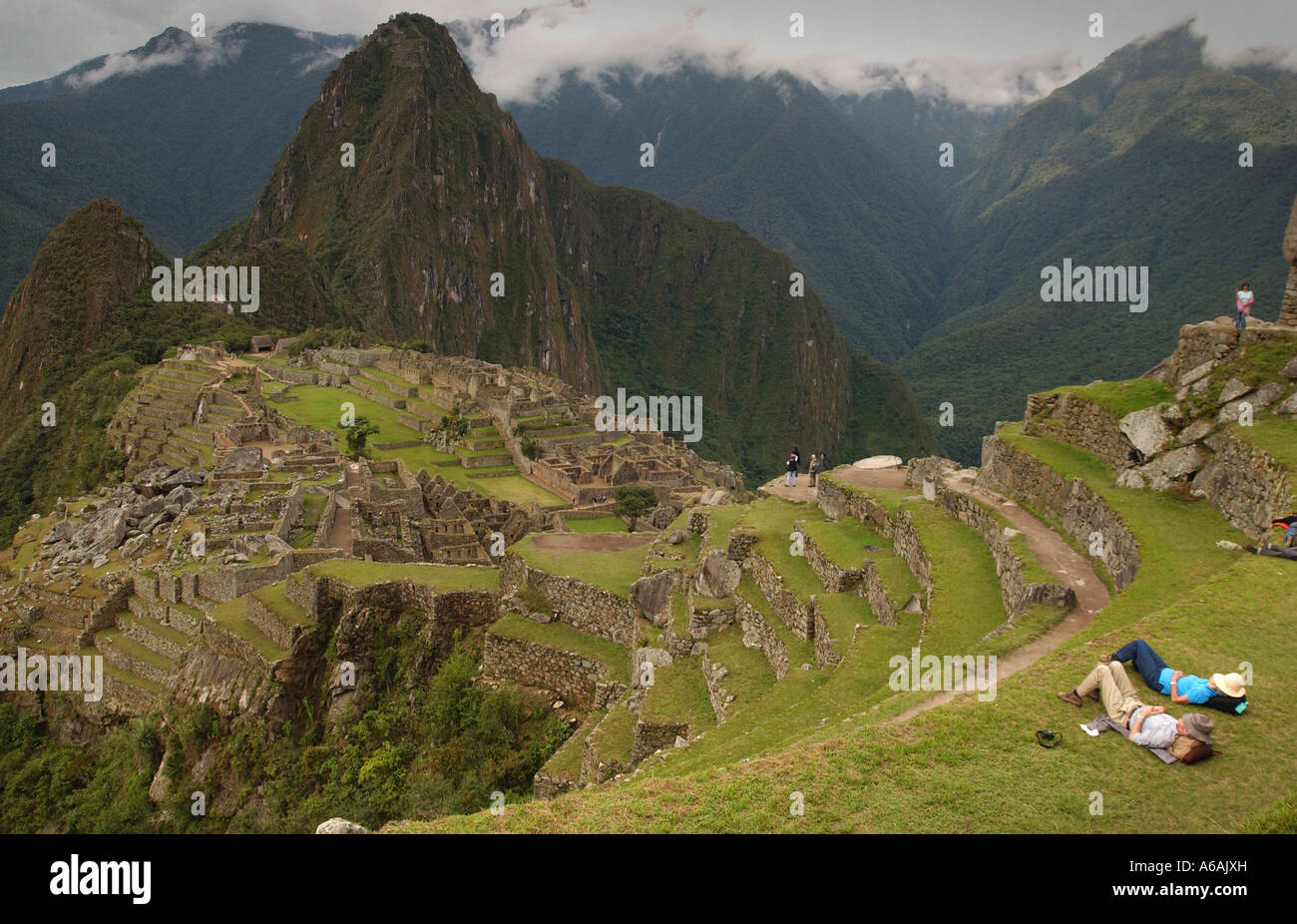 tourists relaxing at the top of Machu Picchu, in Peru, South America ...