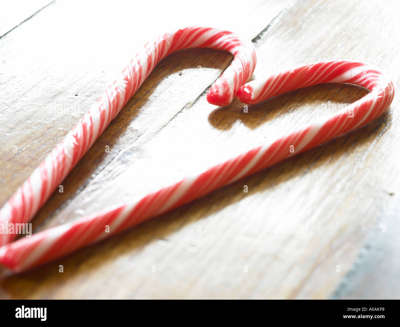 red and white candy cane sticks making a symbol of a hart shape laying ...