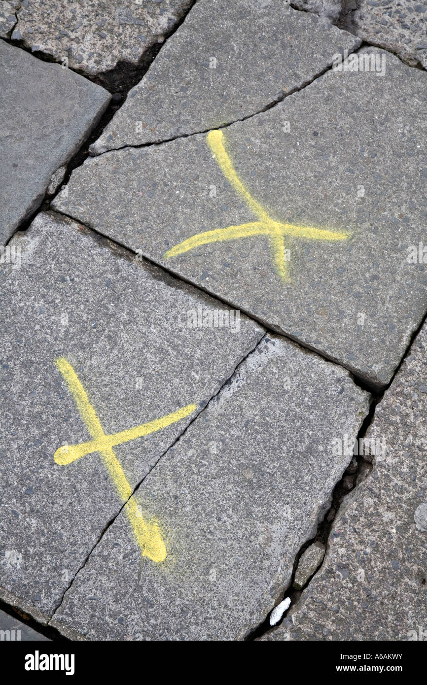 Broken paving slabs marked by the council with yellow paint for repair ...