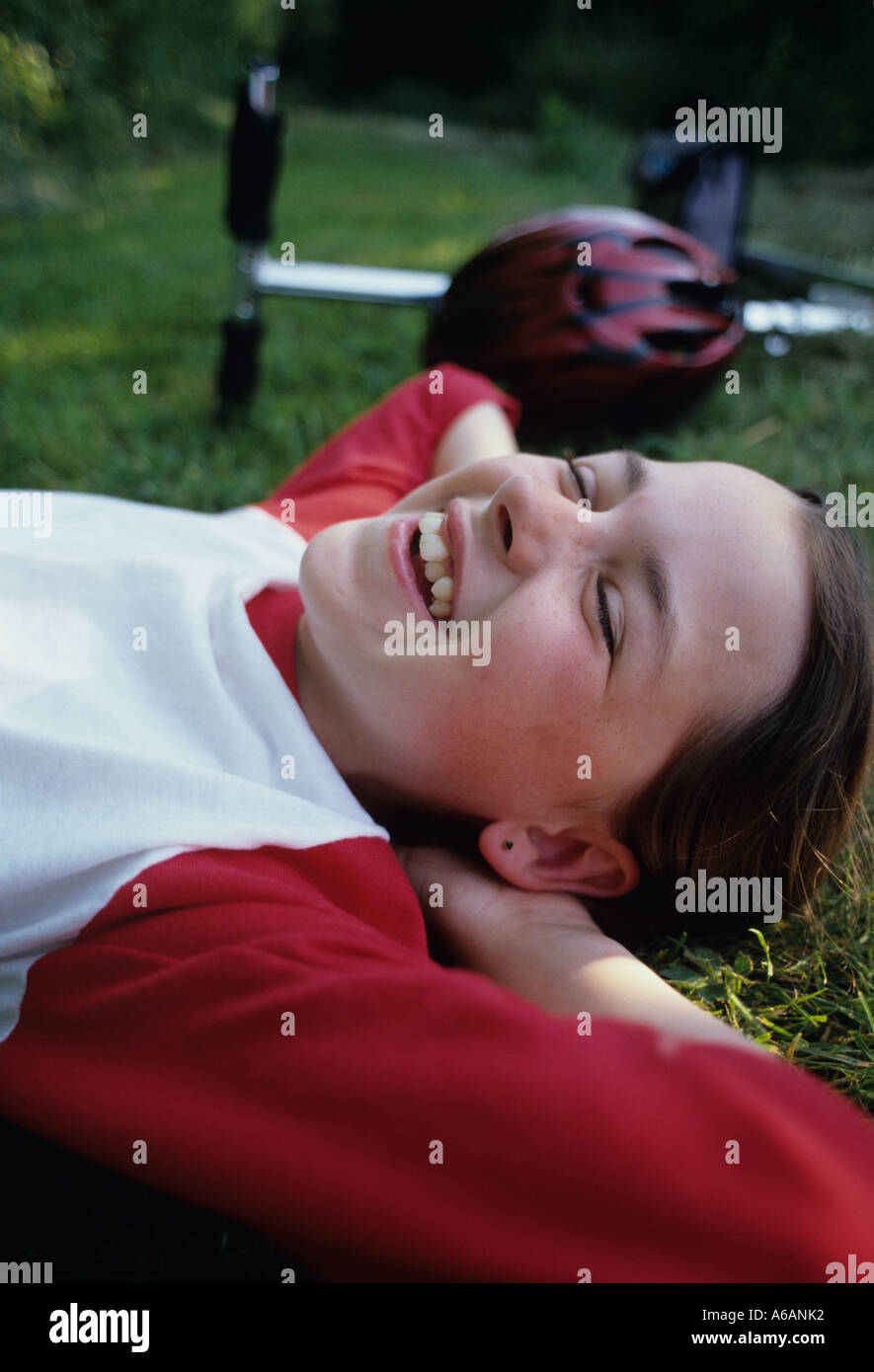 Young girl lying on lake trail laughing Stock Photo - Alamy