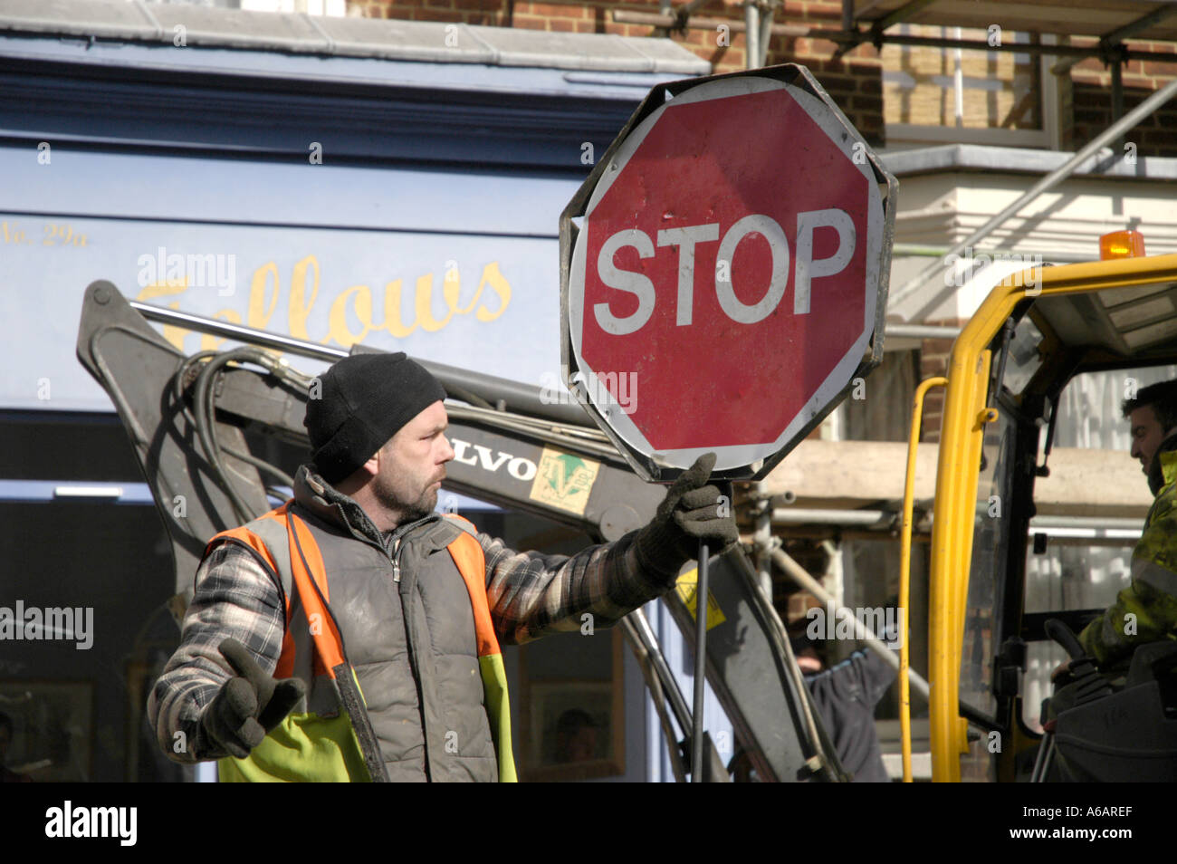 stop go sign and workers at road works Stock Photo - Alamy