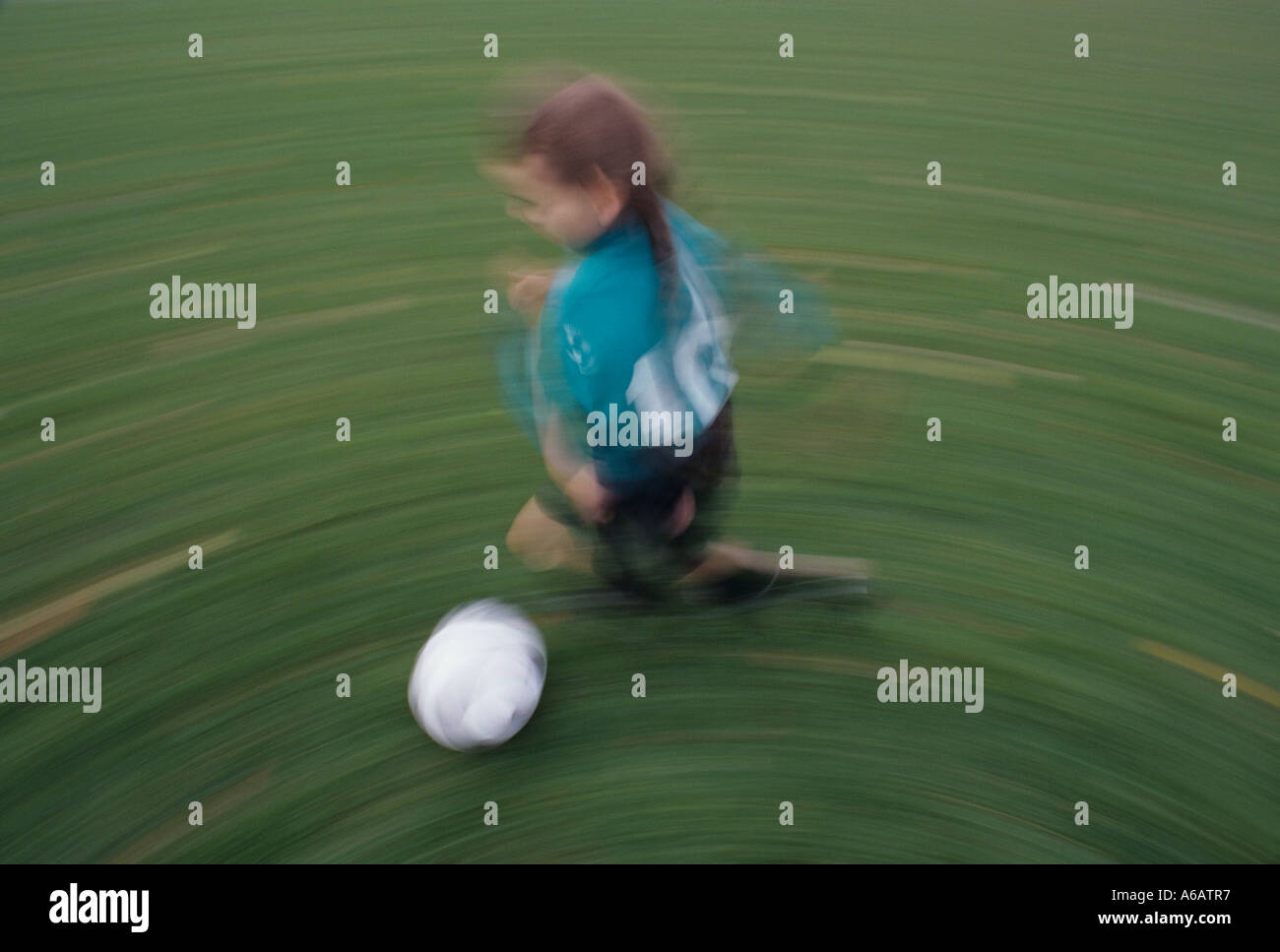 Young girl playing soccer, going after soccer ball running motion Stock ...