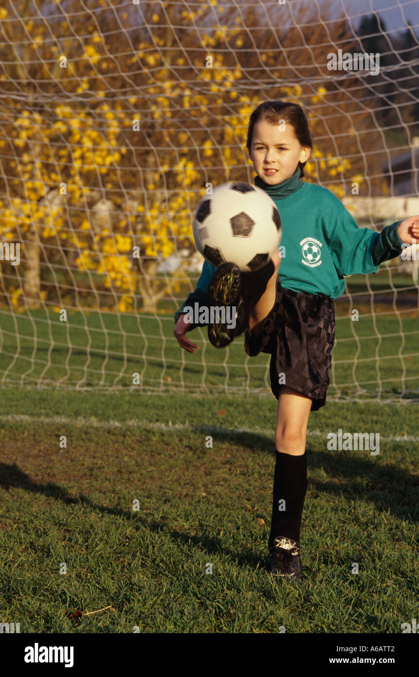 Young girl playing soccer sunset light Stock Photo - Alamy