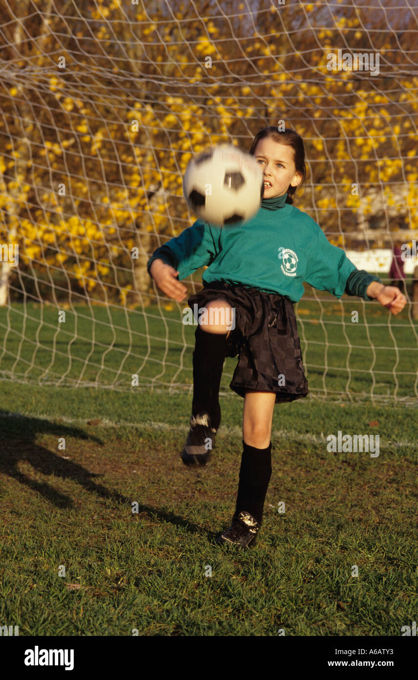 Young girl playing soccer sunset light Stock Photo - Alamy