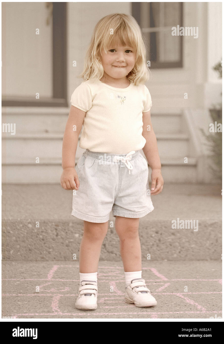Female Child standing in front of house Stock Photo - Alamy
