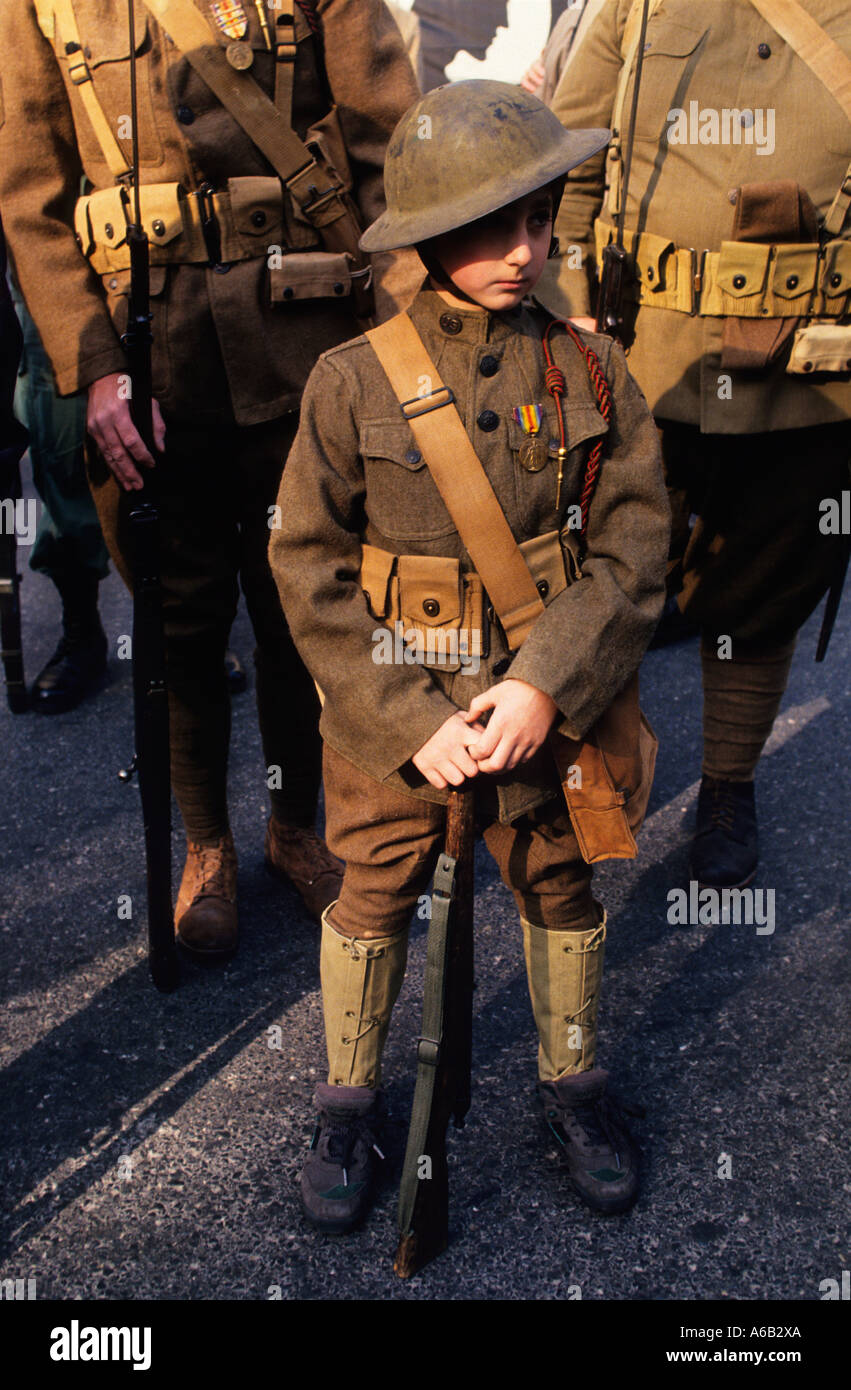 Child dressed in World War I soldier's uniform and helmet and carrying ...