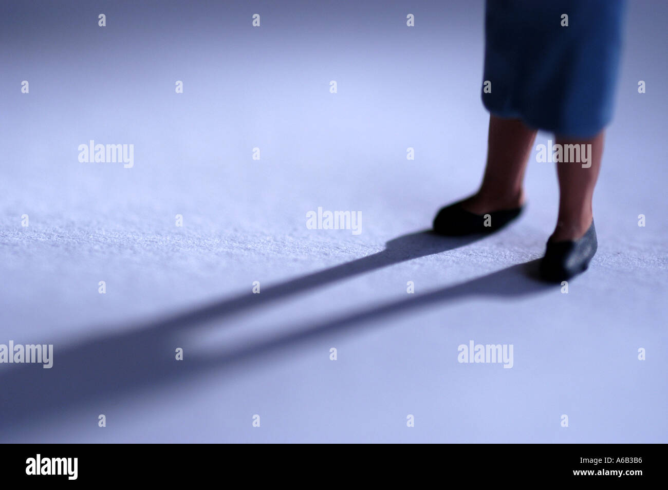 Miniature woman feet shadow blue pin horizontal Stock Photo - Alamy