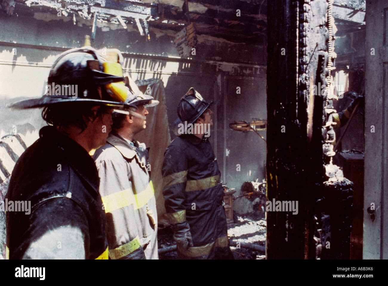 Fireman firefighters inspecting the charred home interior. Firemen ...