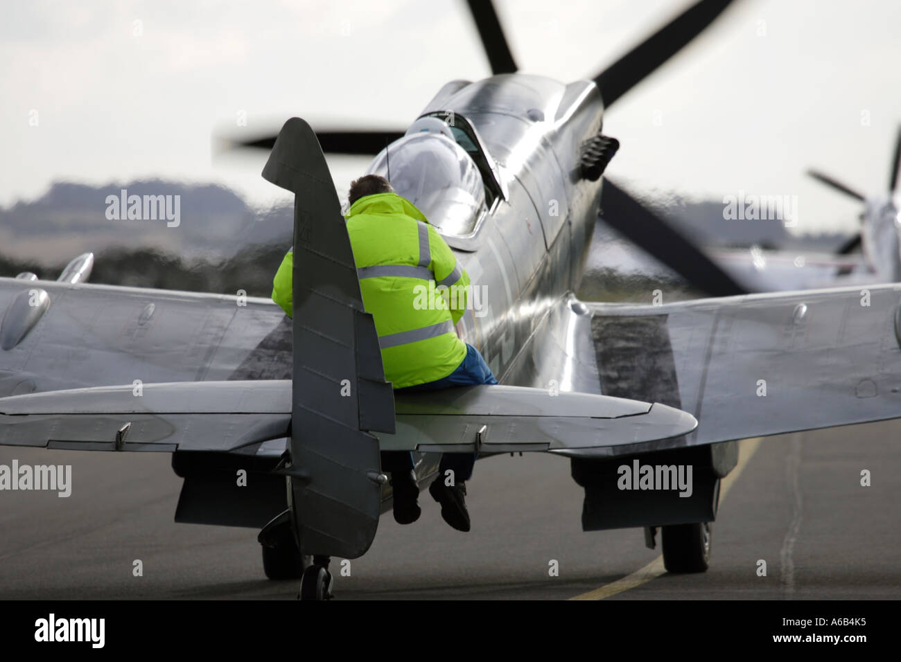 Spitfire with man sitting on tail to hold down Stock Photo - Alamy