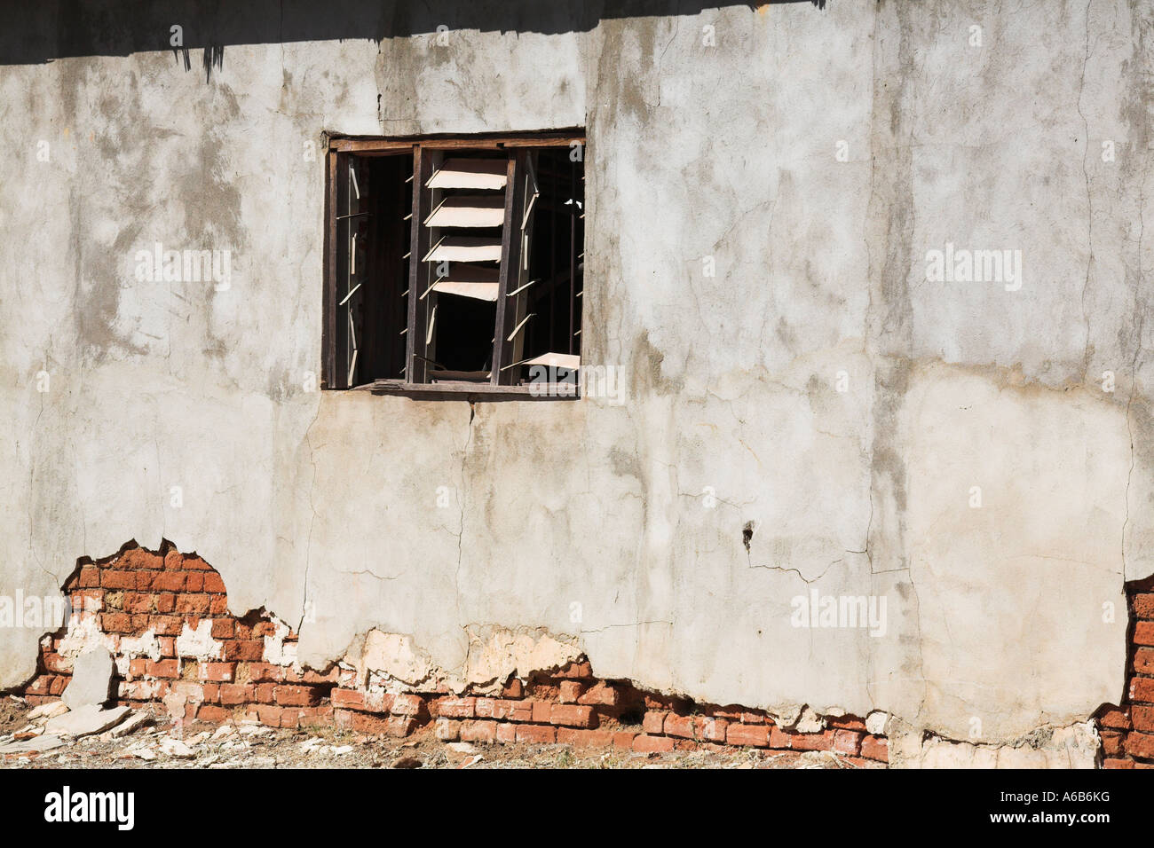 Dilapidated and broken window frame on wall of an old rustic building ...