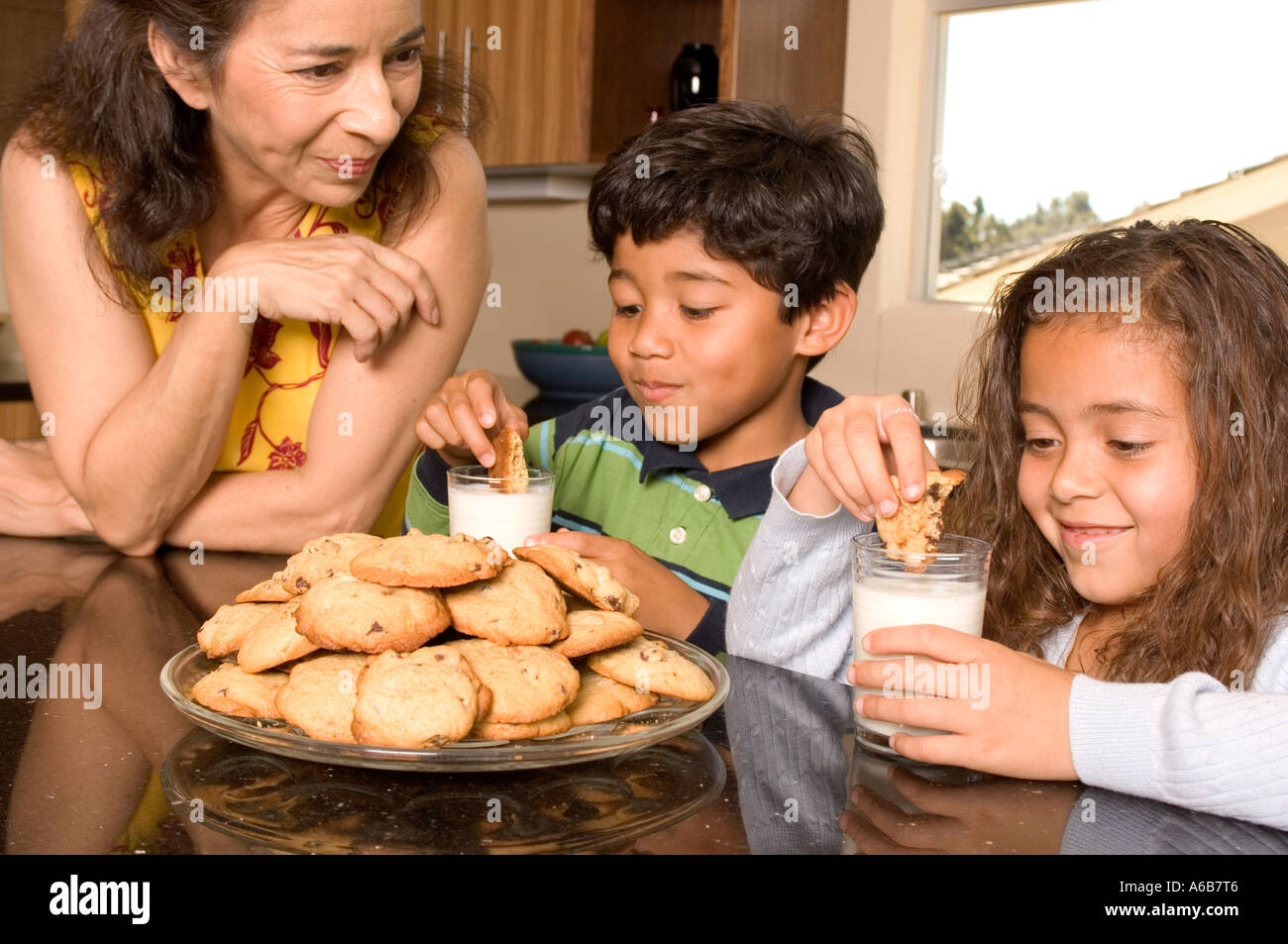 Portrait of mom and kids eating cookies Stock Photo - Alamy