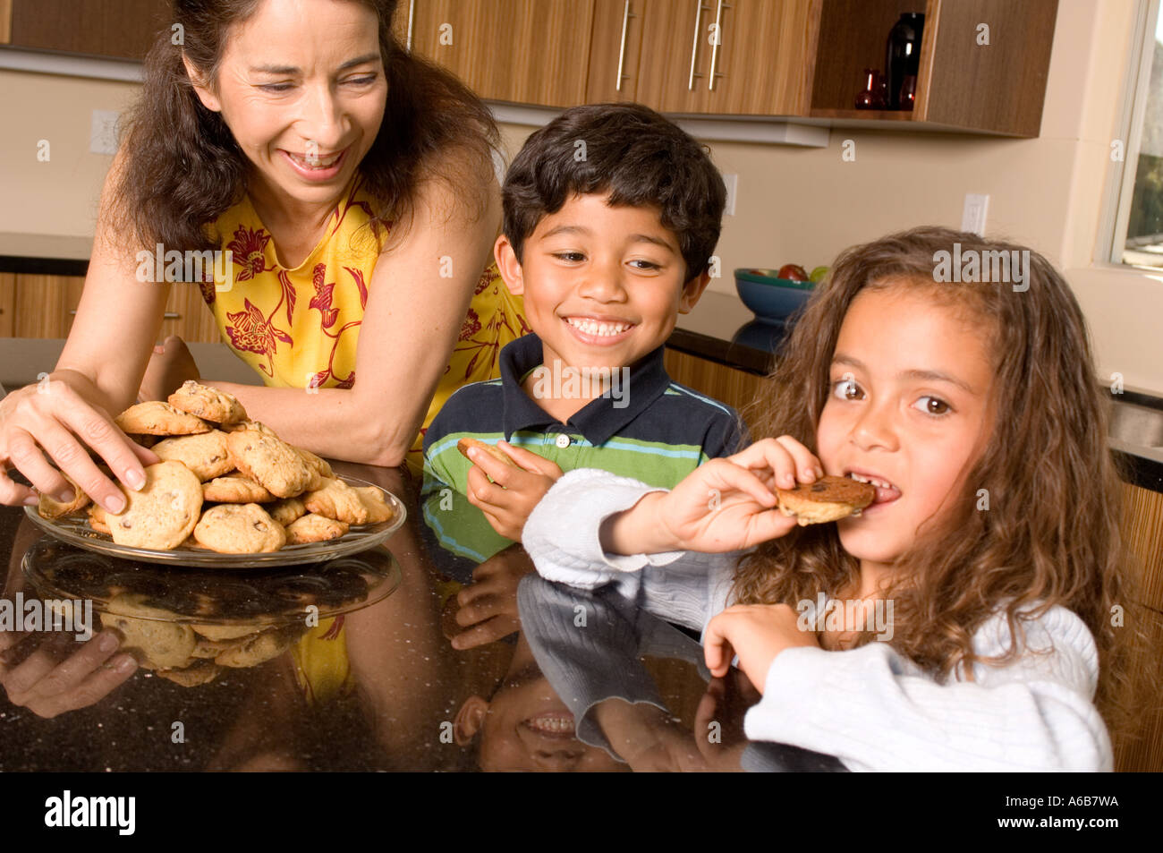 Portrait of mom and kids eating cookies Stock Photo - Alamy