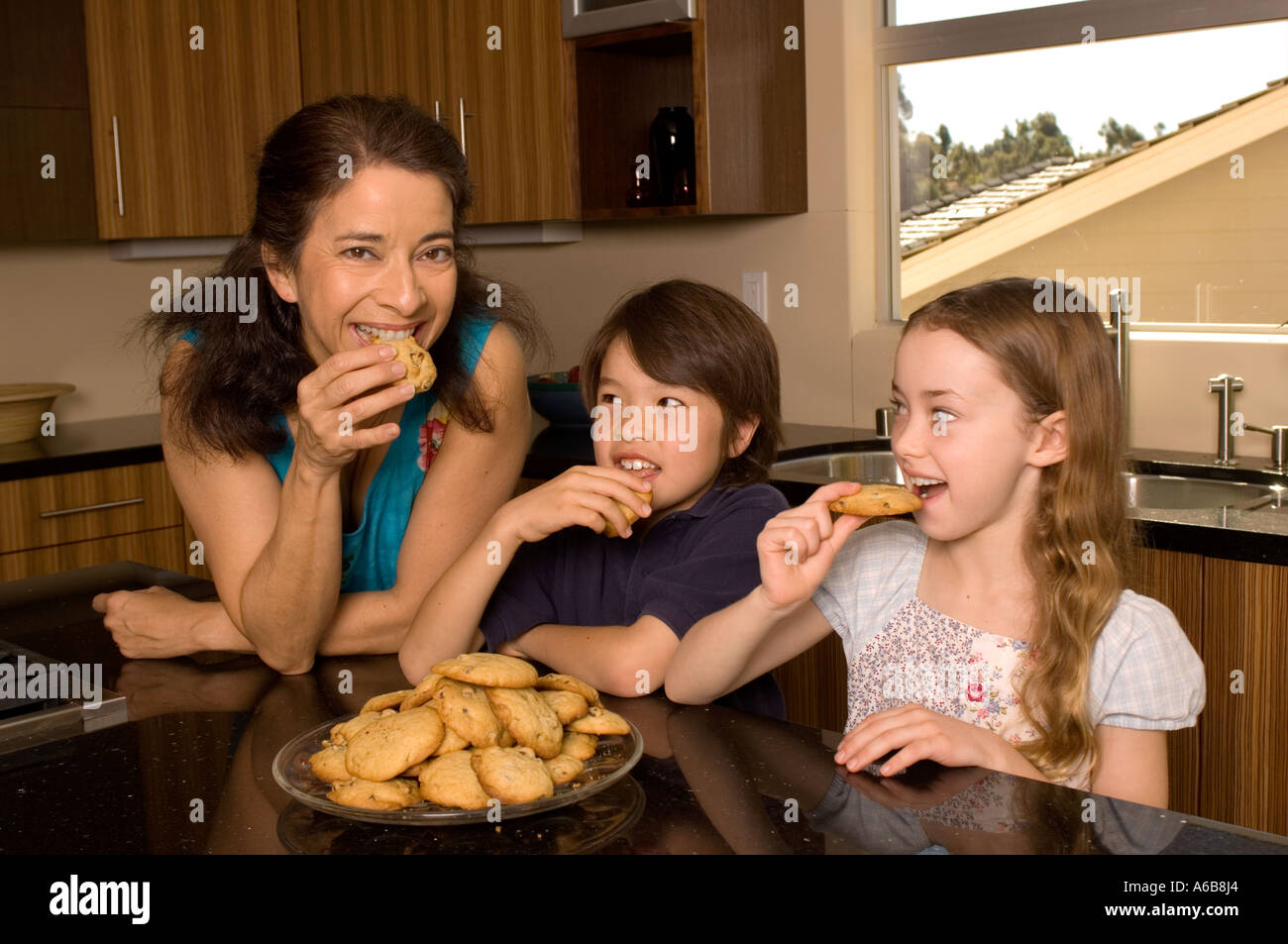 Portrait of mother with kids eating cookies Stock Photo - Alamy