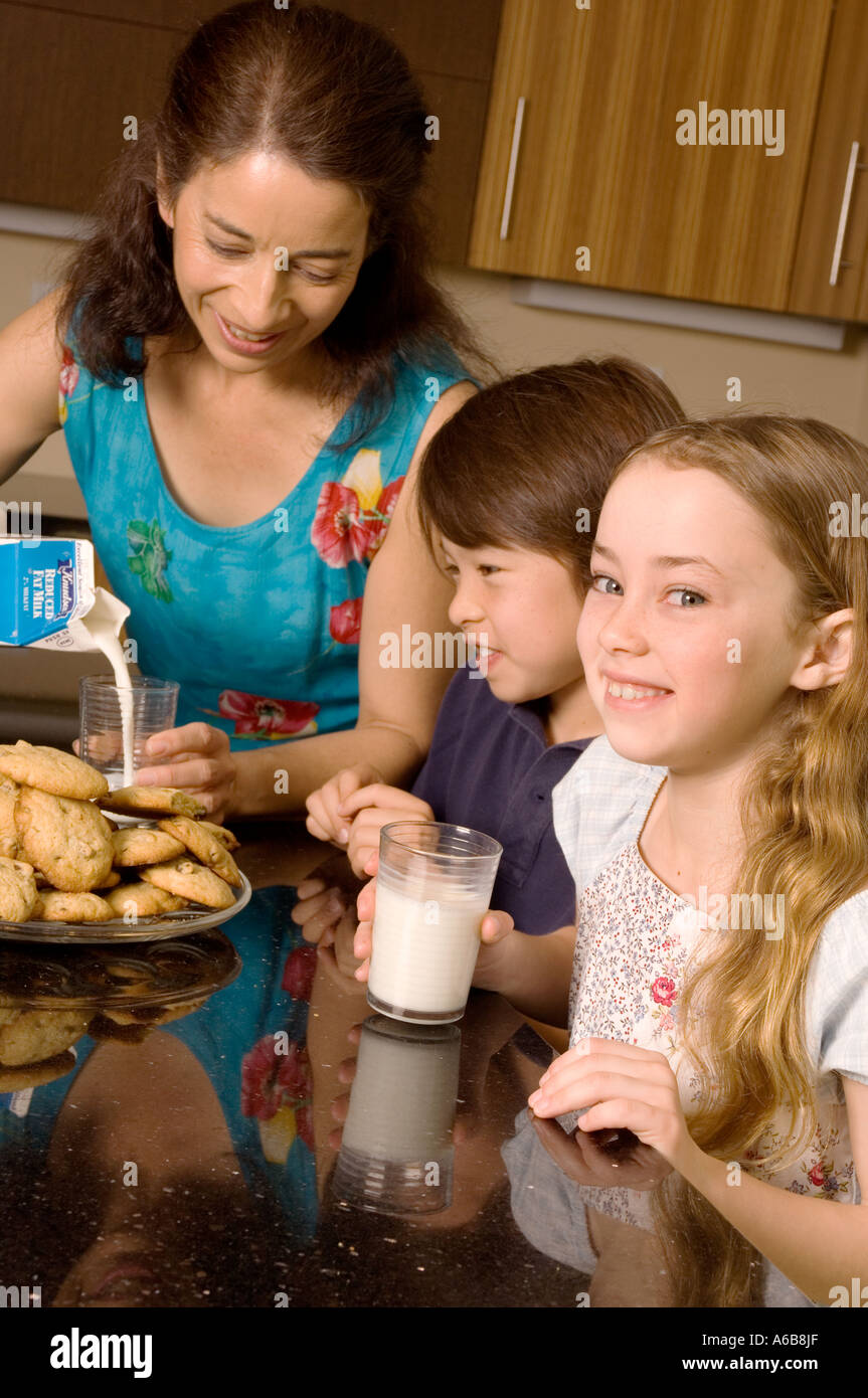 Portrait of mother pouring milk for children Stock Photo - Alamy
