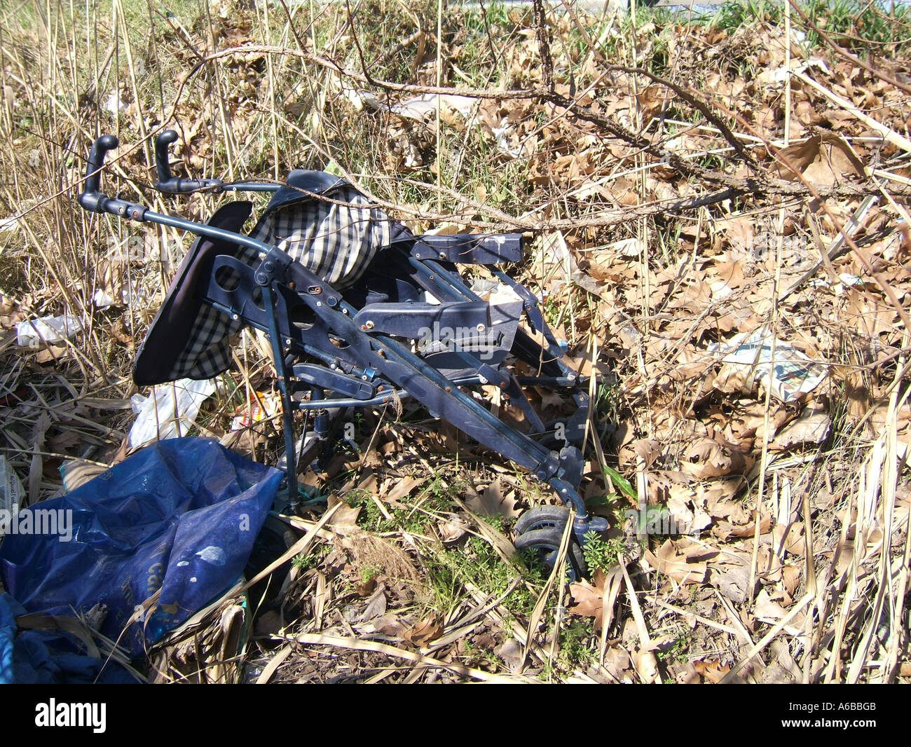 old pram dumped on waste ground Stock Photo - Alamy