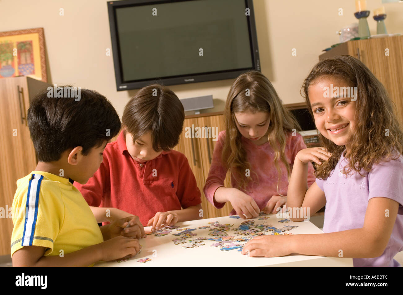 Portrait of kids playing a puzzle Stock Photo - Alamy