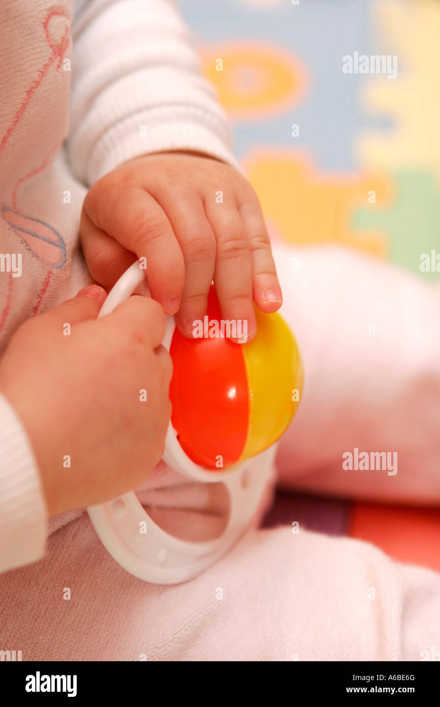 Baby hand holding rattle toy detail hi-res stock photography and images ...