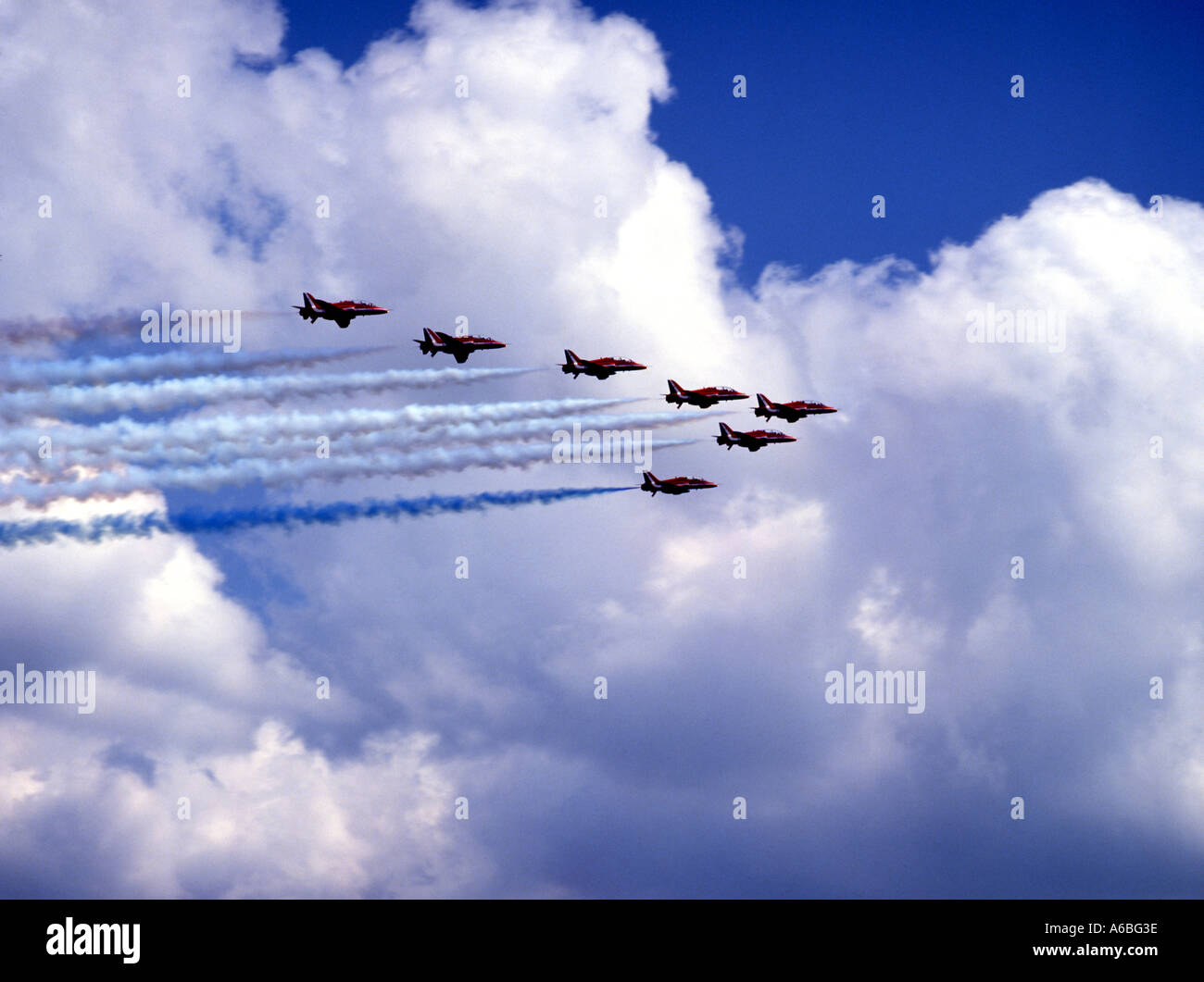 The Red Arrows RAF aerobatic team flying in V formation with coloured ...