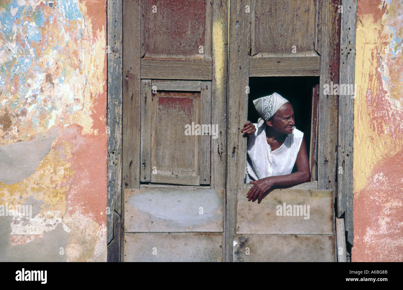 Woman looking out from a window in Trinidad Cuba Stock Photo - Alamy