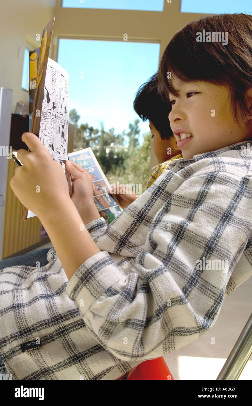 Portrait of Hispanic and Asian boy reading comic books Stock Photo - Alamy